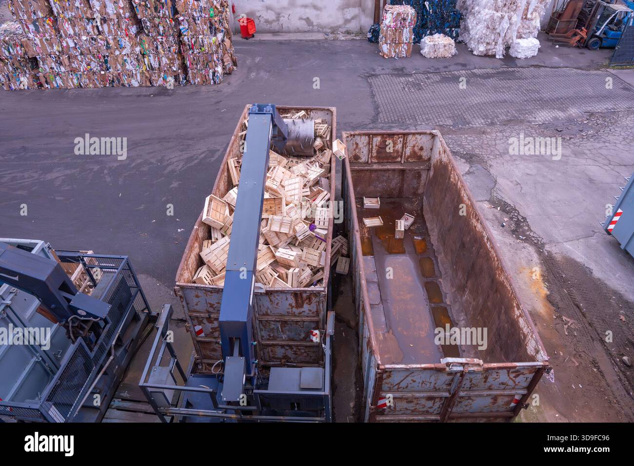Aerial view of a recycling yard with rusted dumpsters, a shredder unit ...