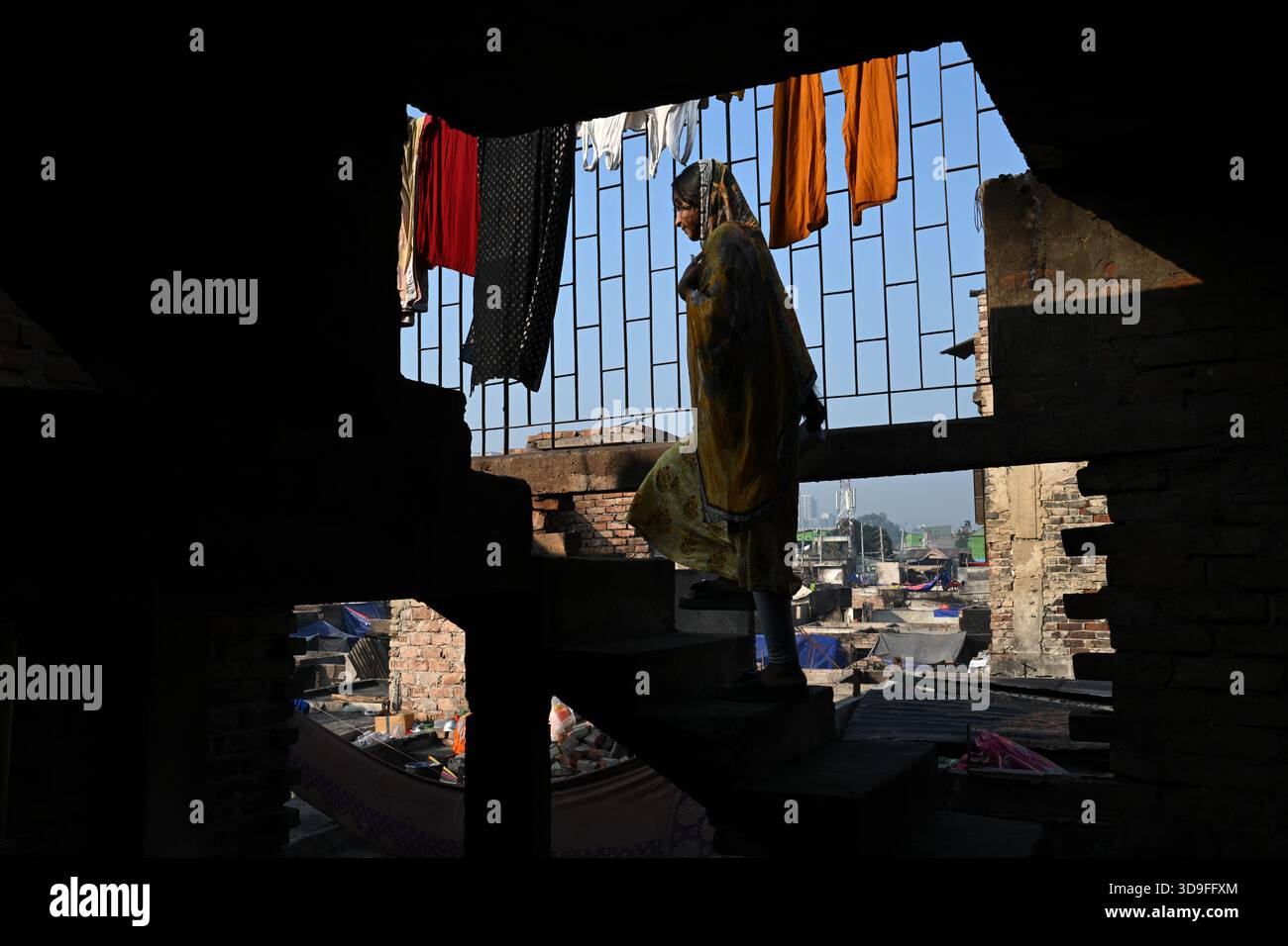 Faria Islam a Class Ten student who lost her books in the Korail slum fire, climbs the stairs of ...