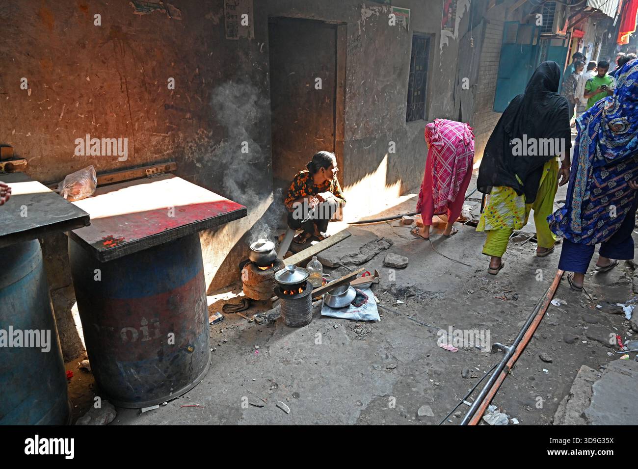 A woman dweller cooks in front of her house in the Korail slum in Dhaka ...