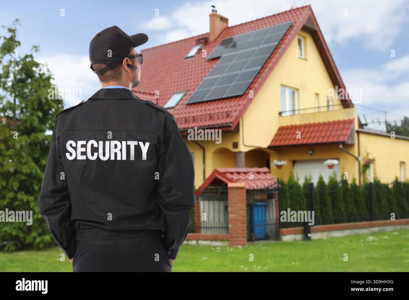 Security guard near house outdoors, back view. Private property ...