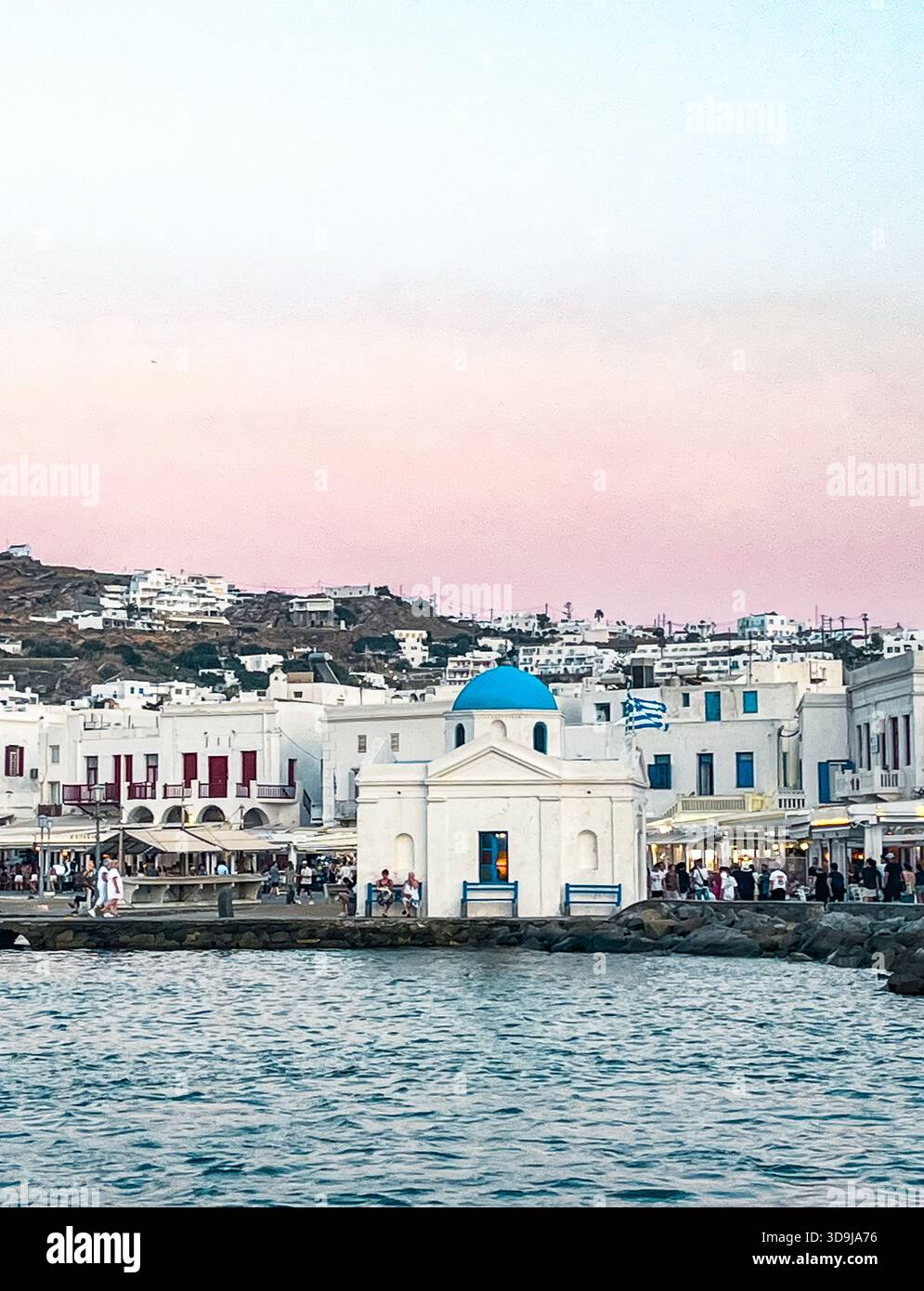 Mykonos at sunset, whitewashed cycladic houses lining the calm aegean ...