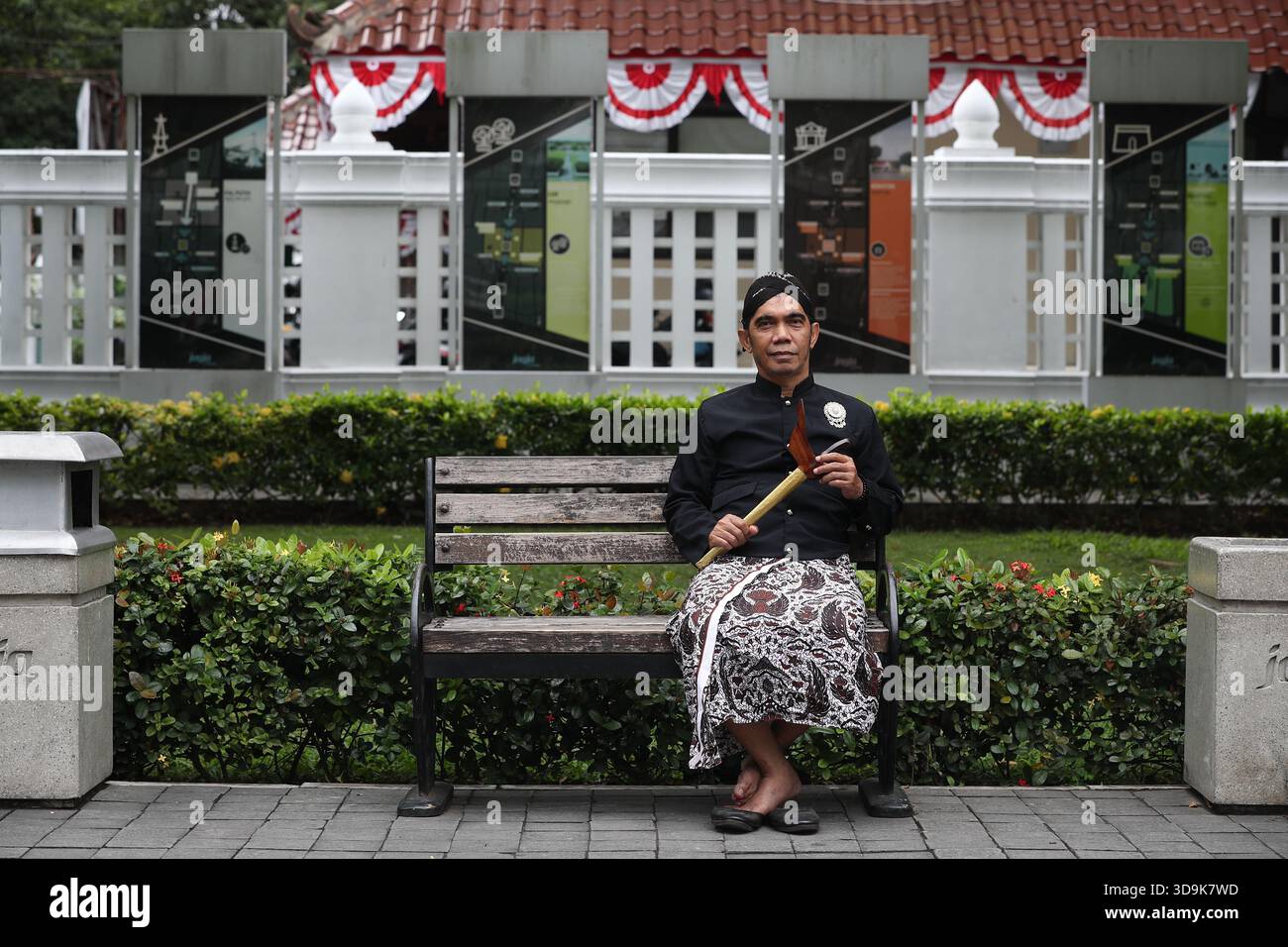 A man poses for a photo in traditional attire while holding a Kris on ...
