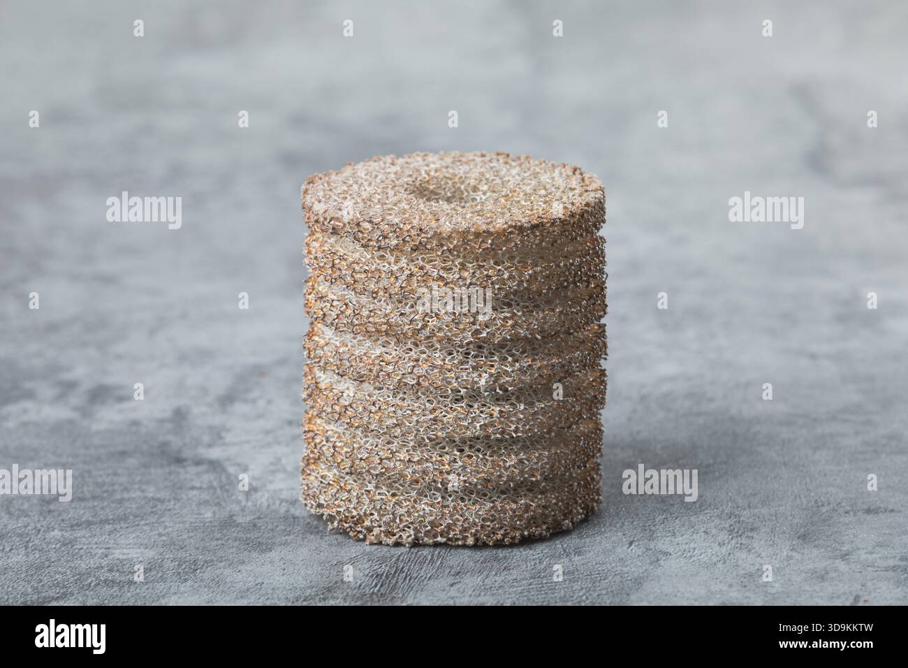 Sponge-like synthetic metal foam on concrete. Close-up view showing ...