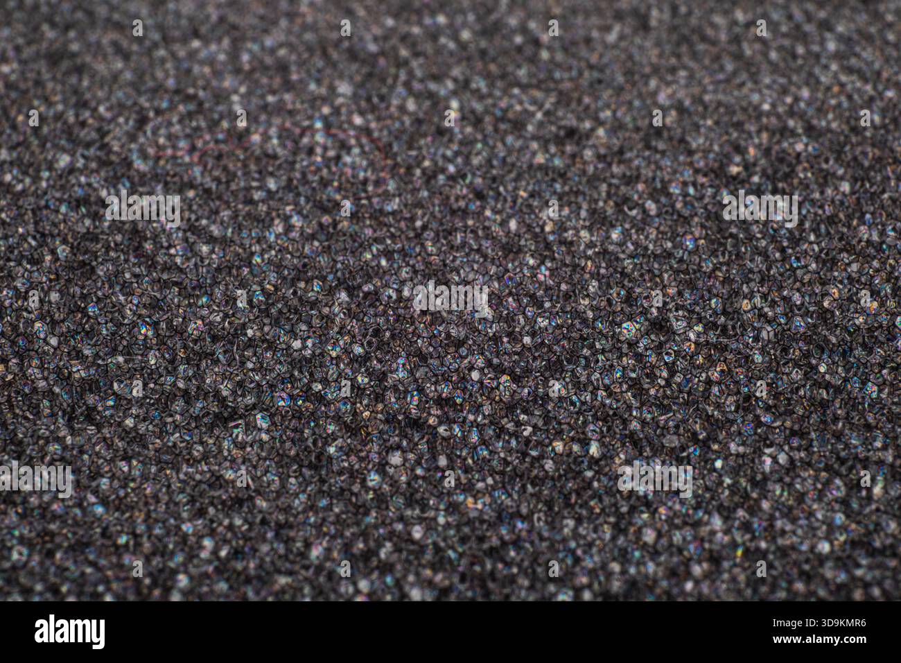 An extreme close-up of a, rough surface reveals a dense, sparkling ...