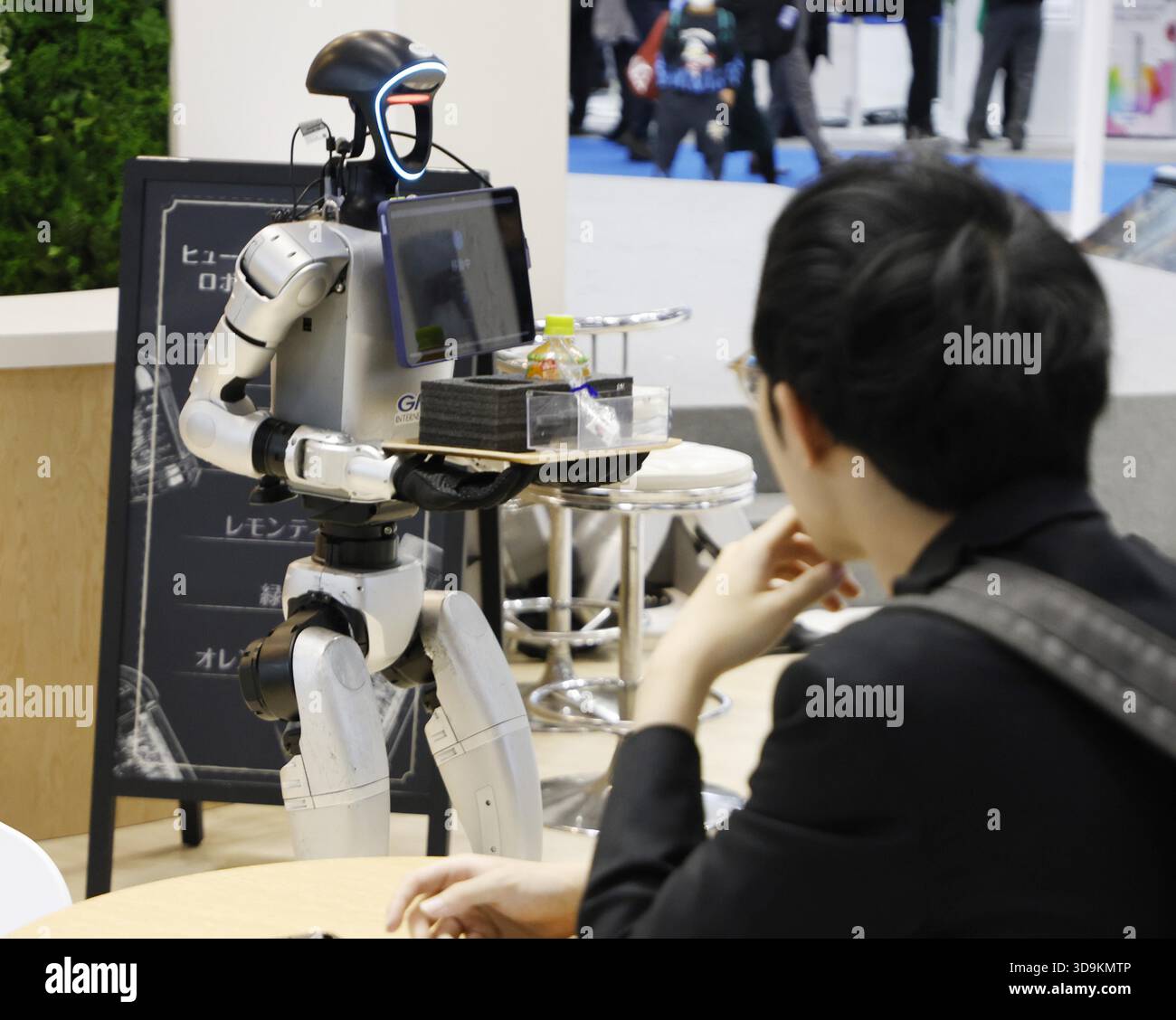 A humanoid robot developed by China's Unitree Robotics carries a tray ...