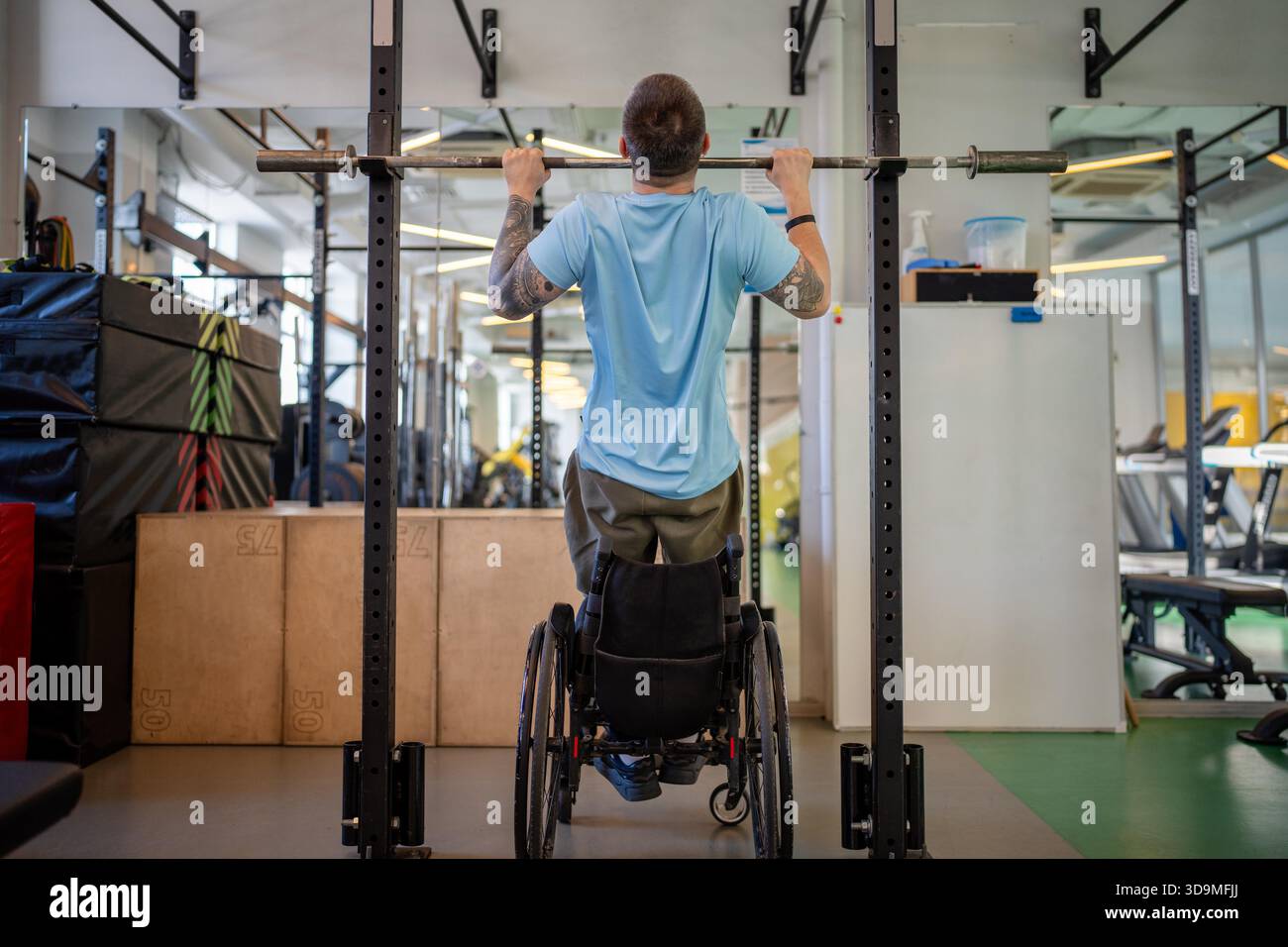 Back view determined man in wheelchair do vertical pull to strengthen ...