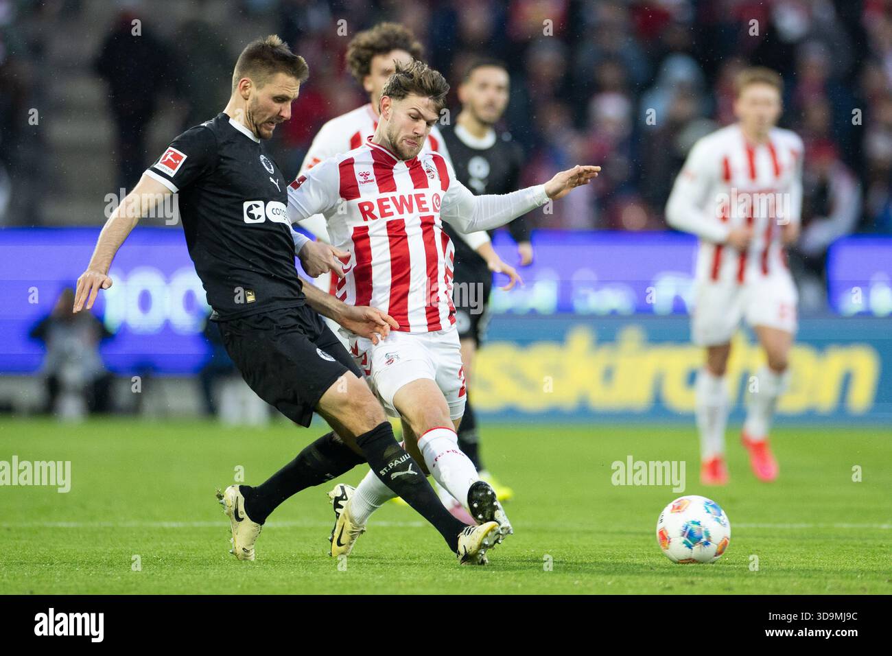 St. Pauli's Karol Mets, left, and Cologne's Jan Thielmann, right ...