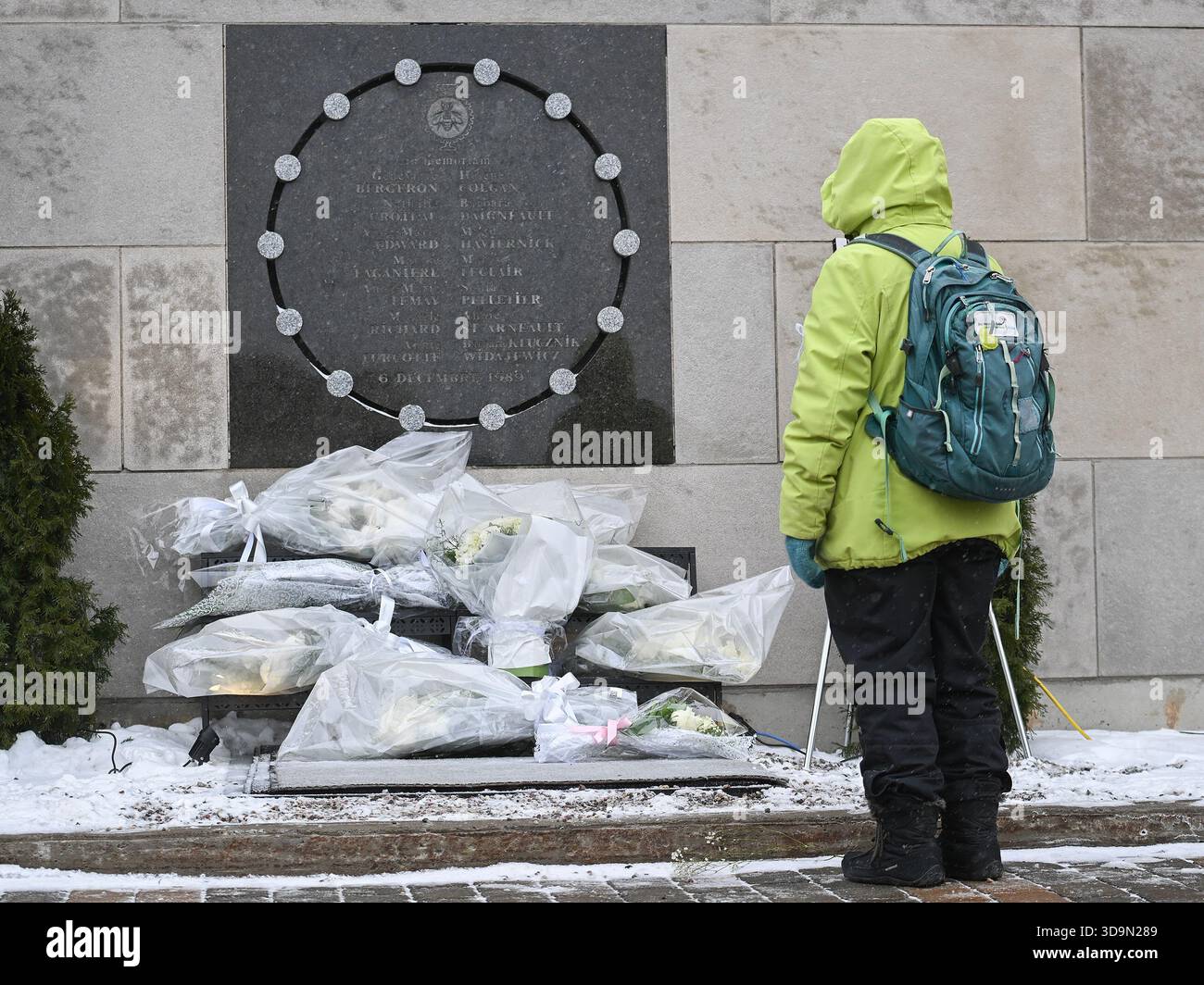 A person stands next to a memorial plaque for the victims of the 1989 ...