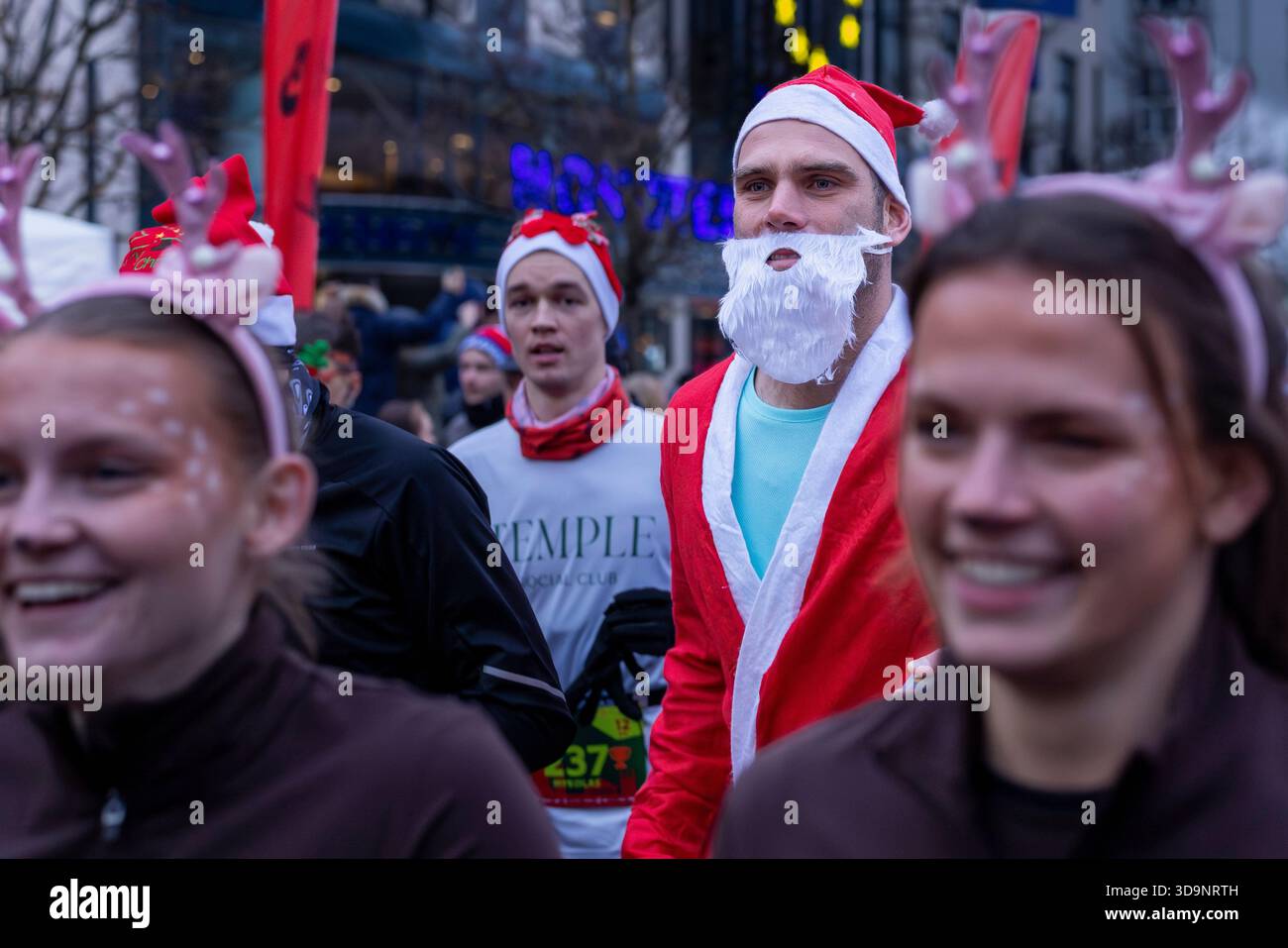 A runner dressed as Santa Claus, runs from the start line of the ...