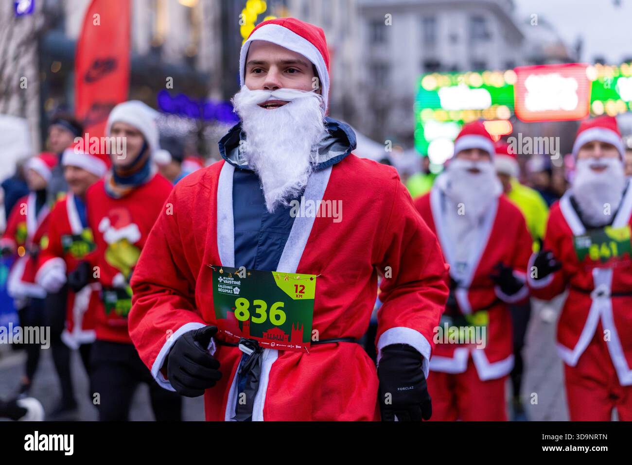 Runners dressed as Santa Claus, run from the start line of the ...
