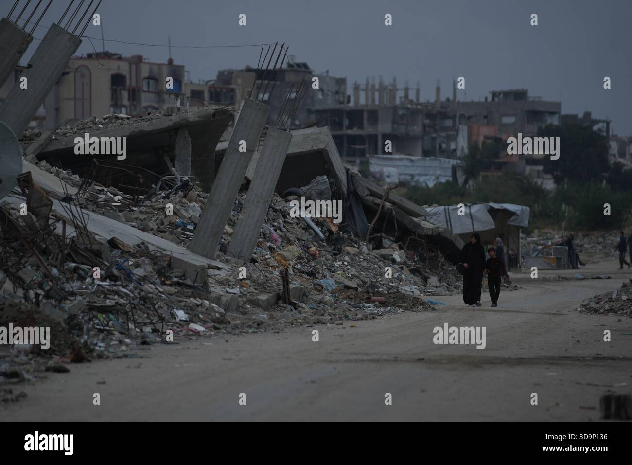 Palestinians walk on a street in Jabaliya, northern Gaza Strip ...