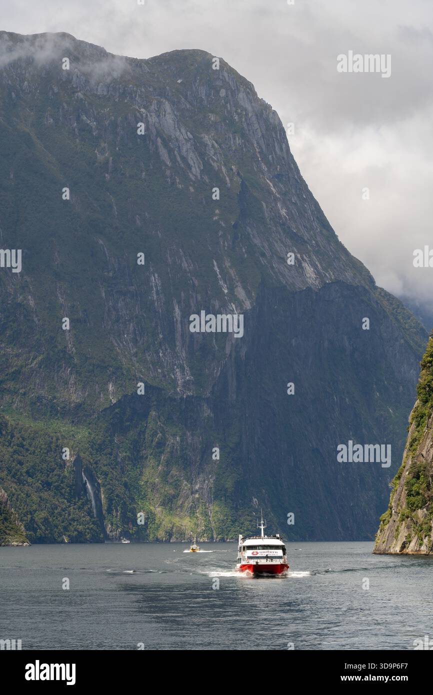 Cruise Boat Navigating Deep Fjord of Milford Sound with Sheer Cliff ...