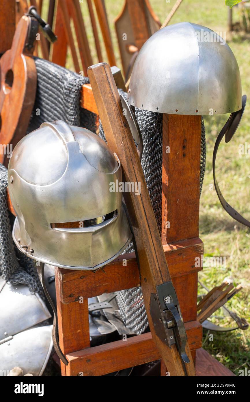 Medieval steel helmets and weapons on a wooden stand Stock Photo - Alamy