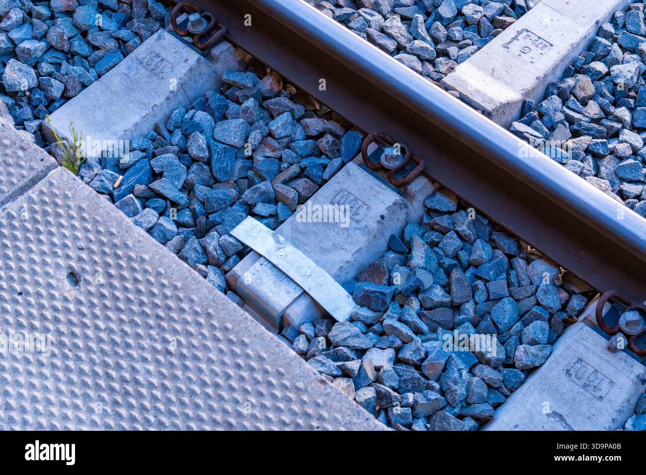 A detailed close-up of a railway track section shows the metal rail ...