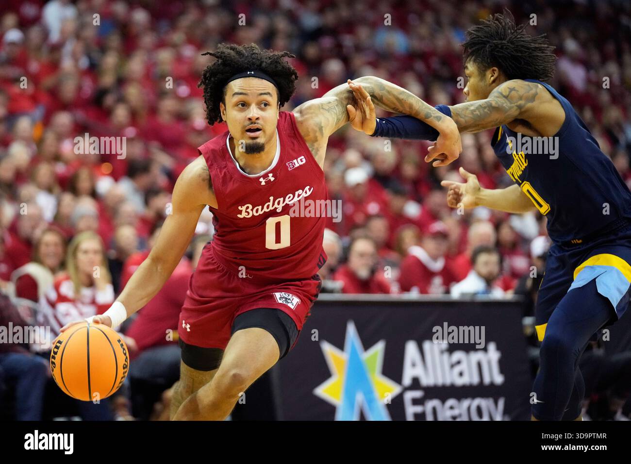 Wisconsin guard Braeden Carrington (0) dribbles pass by Marquette guard ...