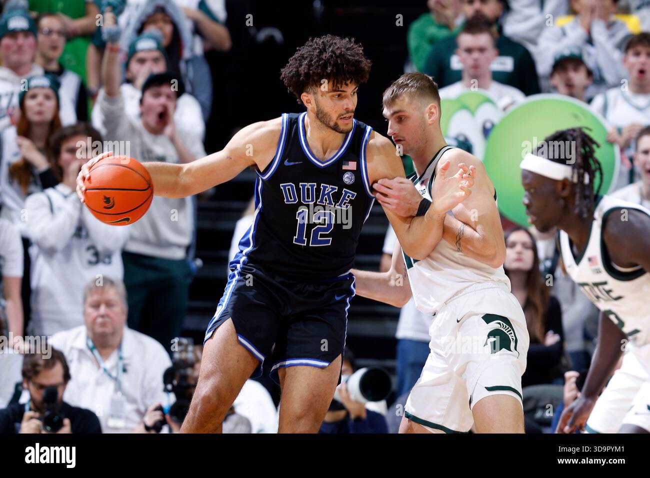 Duke forward Cameron Boozer (12), left, maneuvers against Michigan ...