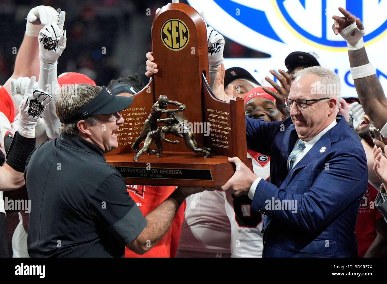 Georgia head coach Kirby Smart is handed the SEC trophy by Commissioner ...