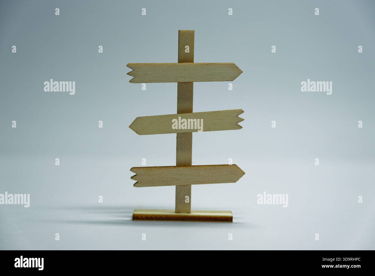 A decorative wooden post displays three horizontal arrows sequentially ...