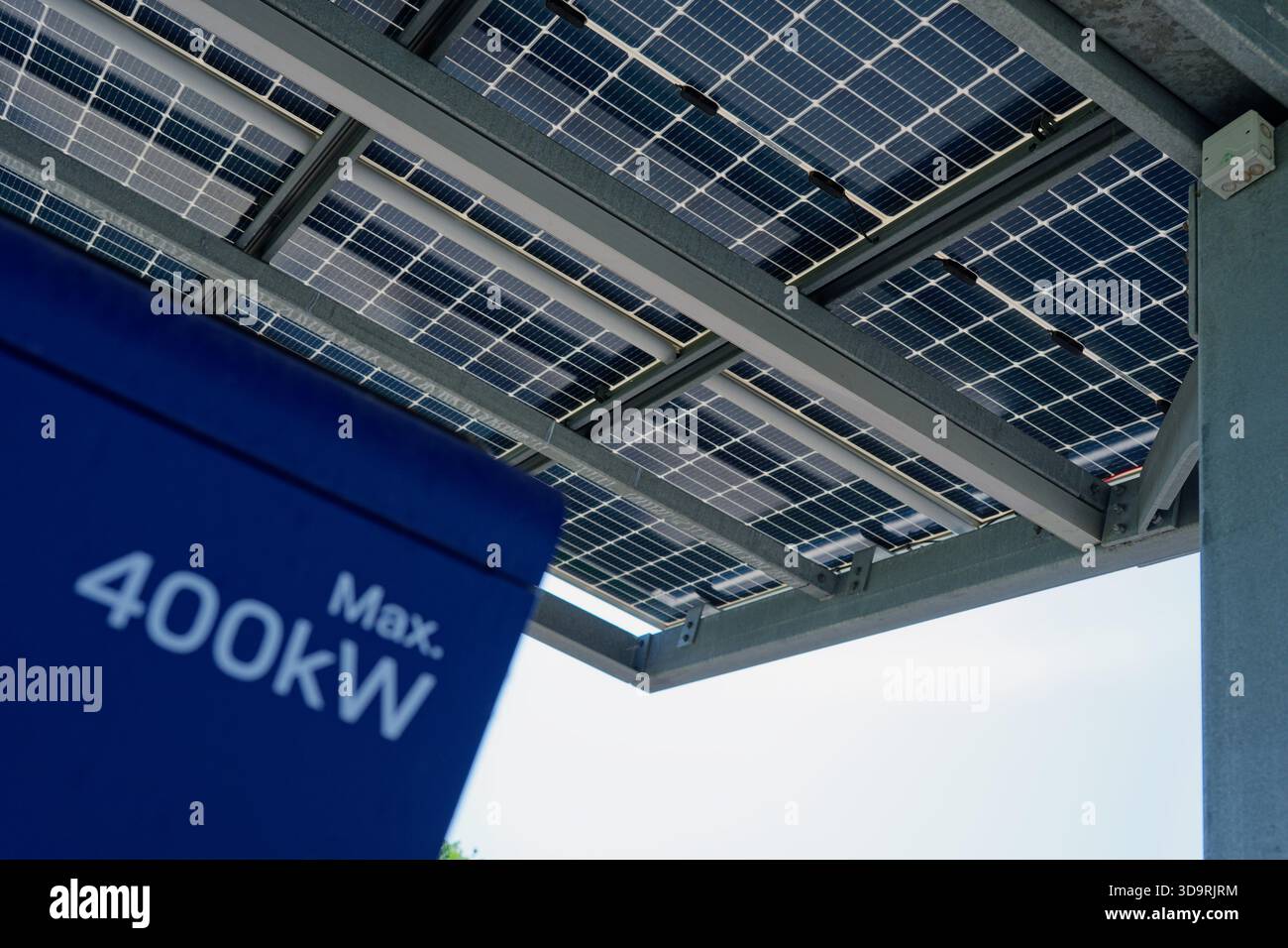 Solar panels mounted on a metal frame near a blue box labeled with ...