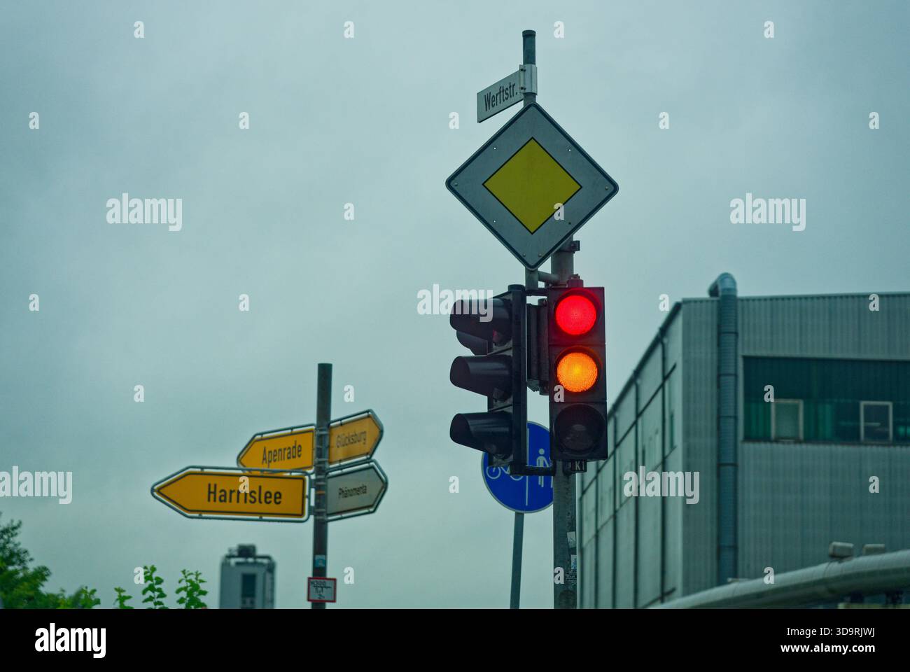 A red and yellow traffic light at a German intersection with multiple ...
