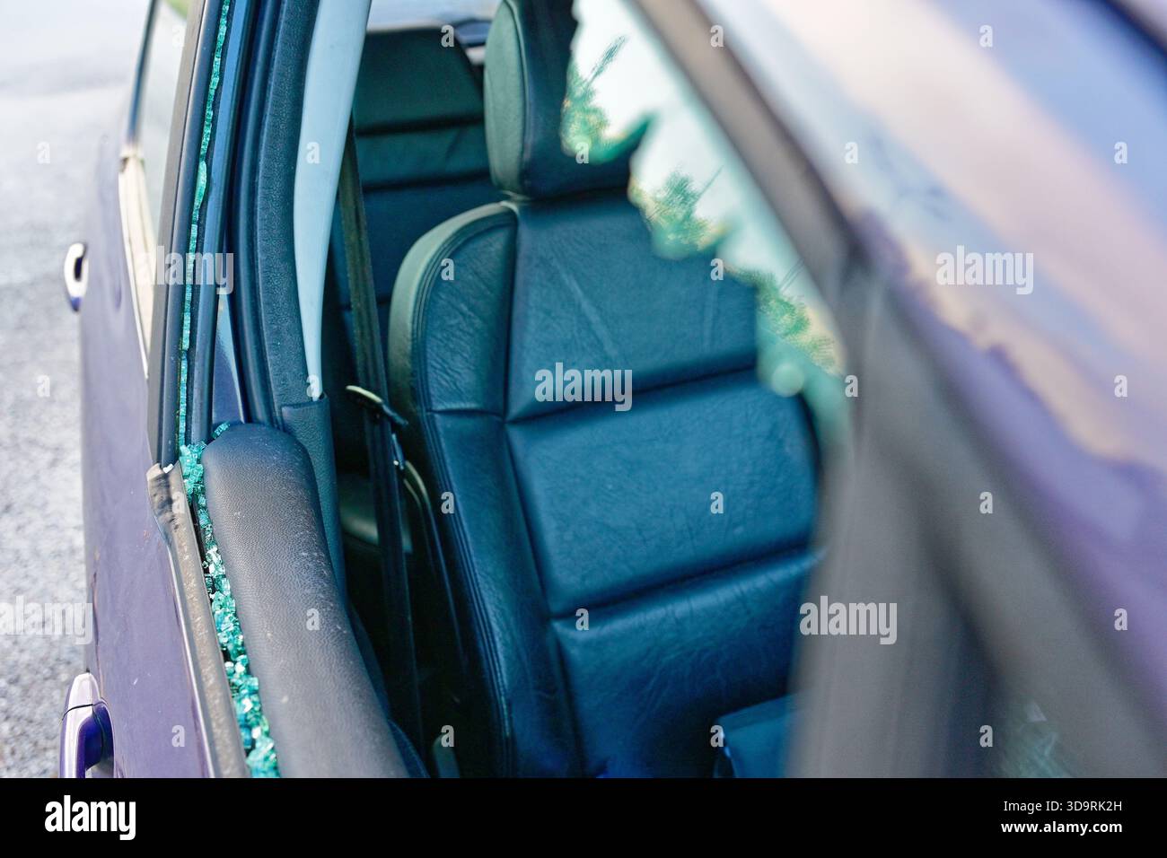 A purple car with a shattered passenger side window displays broken ...