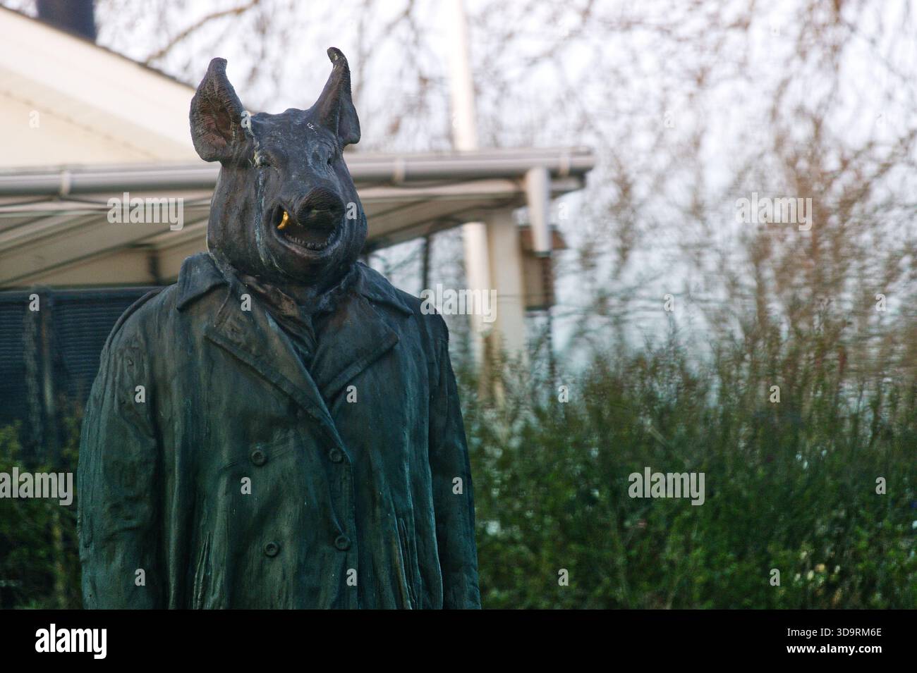 A life size statue depicts a human body wearing a coat but with a pig’s ...