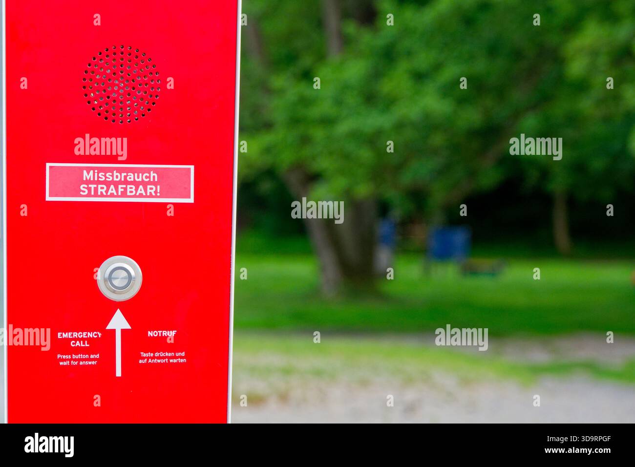 A bright red emergency call box with a speaker outlet and button stands ...