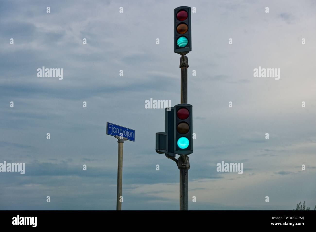 Two signal heads share one pole at different heights, below them a blue ...