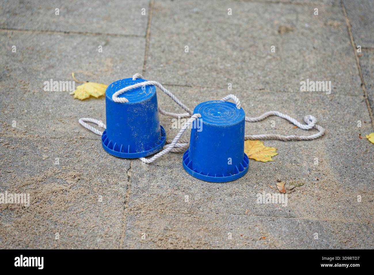 Two blue plastic cups connected by a string forming a toy telephone on ...