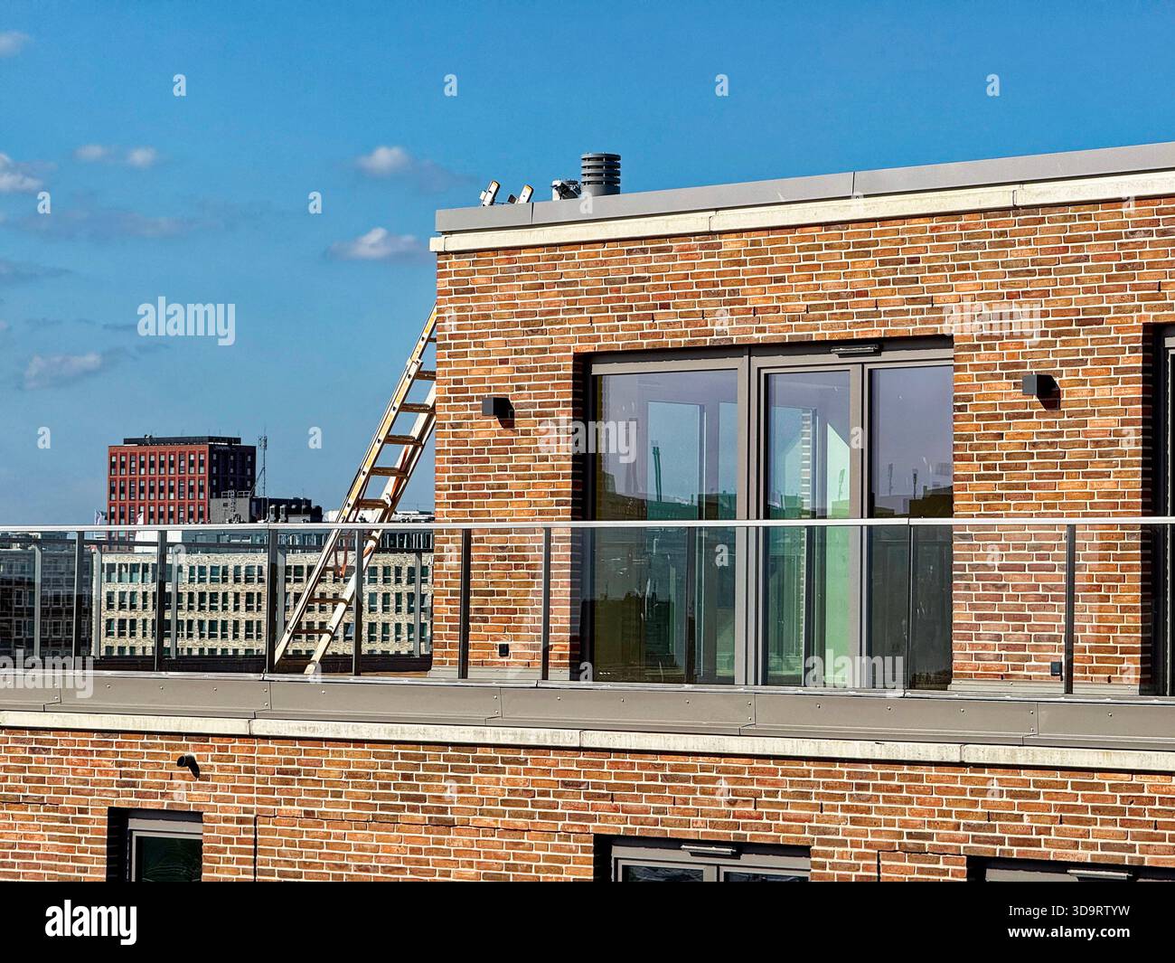Contemporary urban architecture featuring rooftop terrace with glass ...