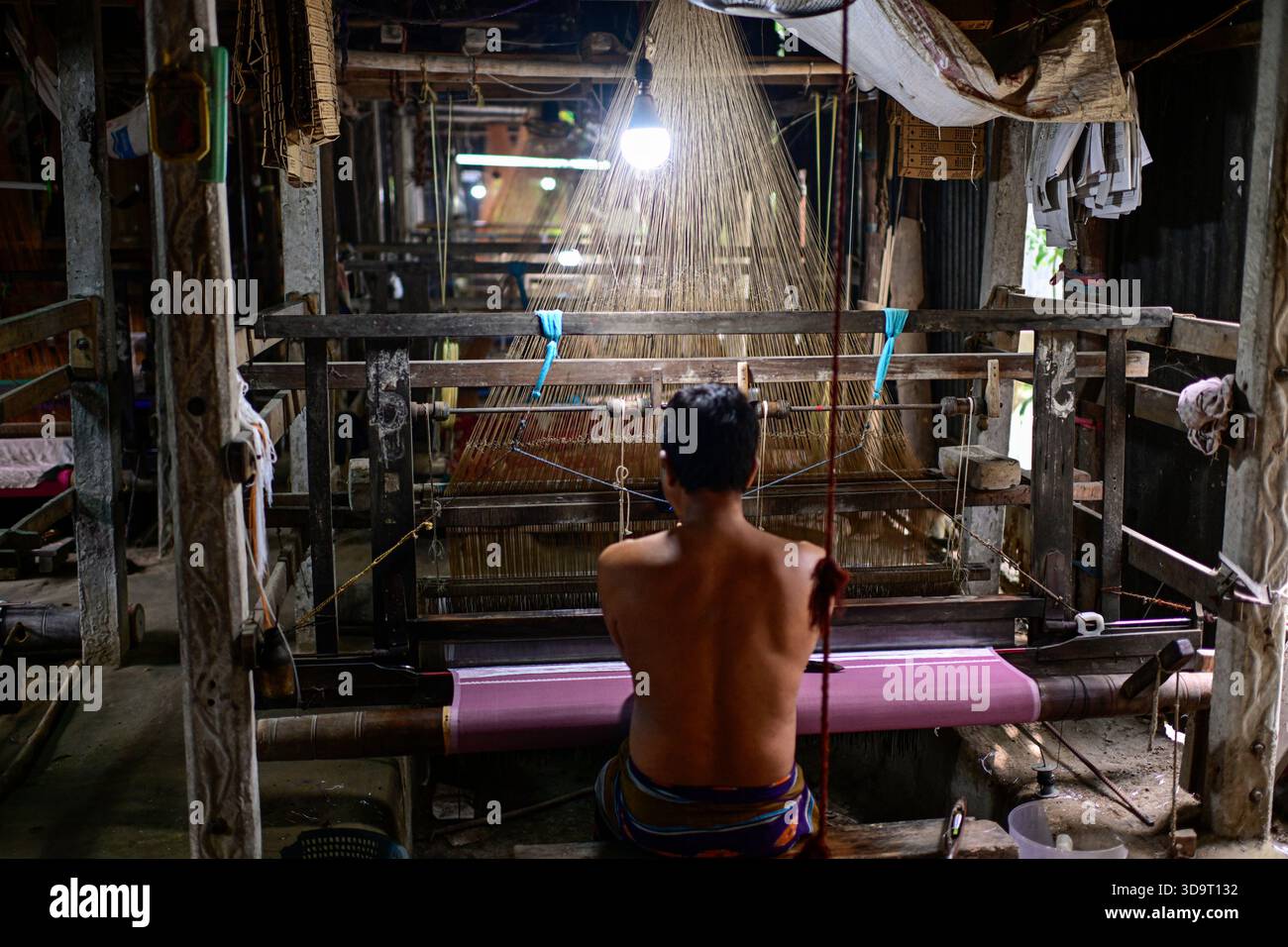 A weaver crafts a Tangail saree on a traditional hand-operated loom at ...