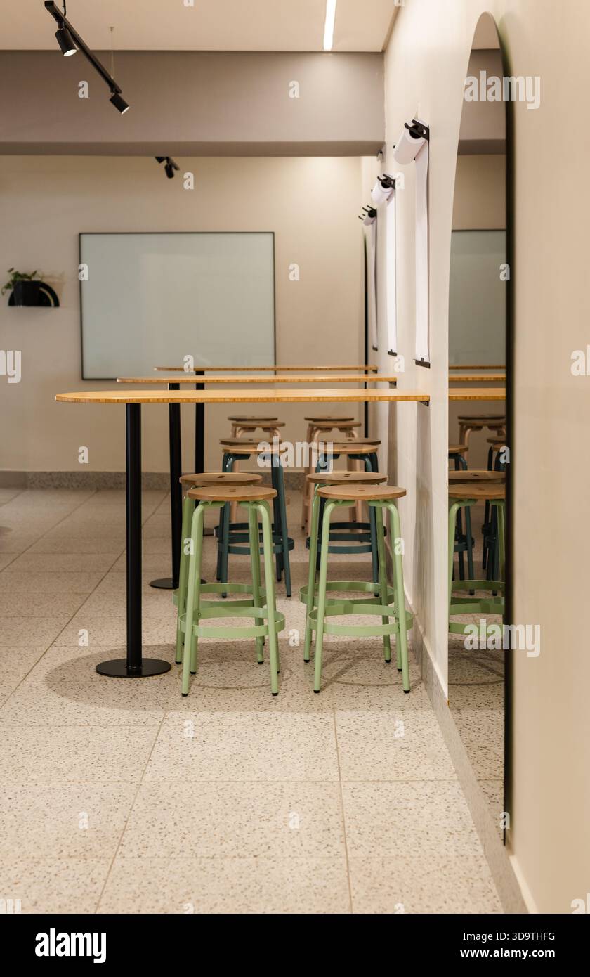 Cluster of three pale green stools sitting under wooden bar table ...