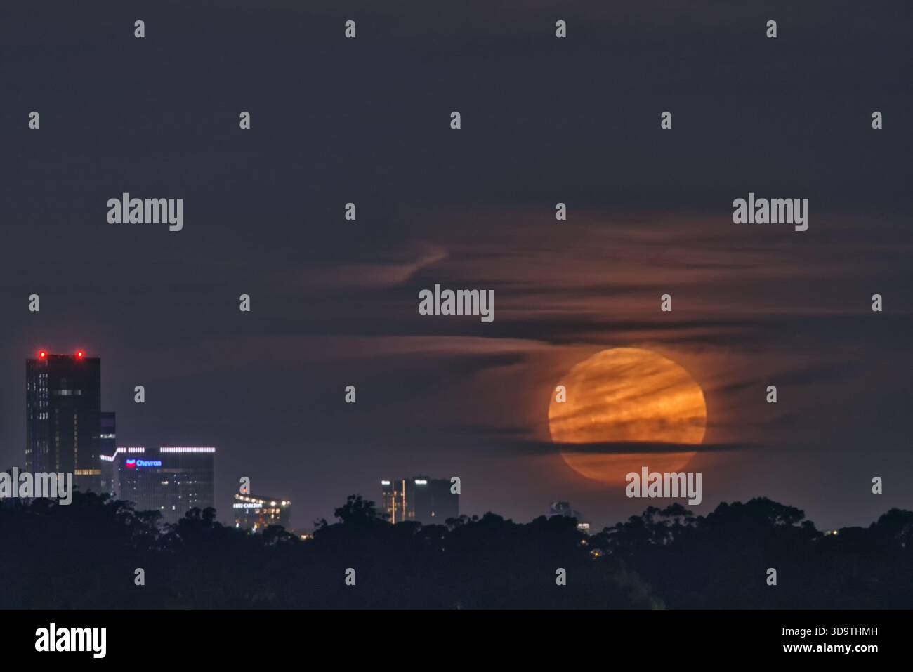 A slightly cloudy moonrise with the December supermoon behind the Perth ...