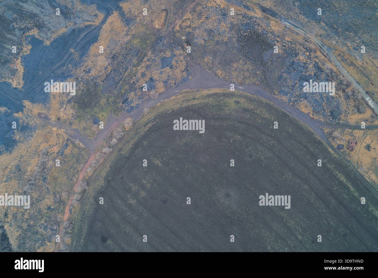 Aerial drone shot of a muddy track curving through a war zone. Top down ...