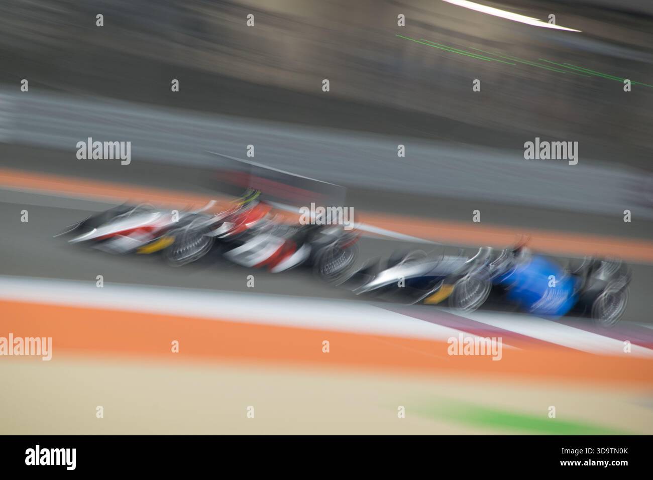 Two race cars speed past each other on the track during the Qatar Grand ...