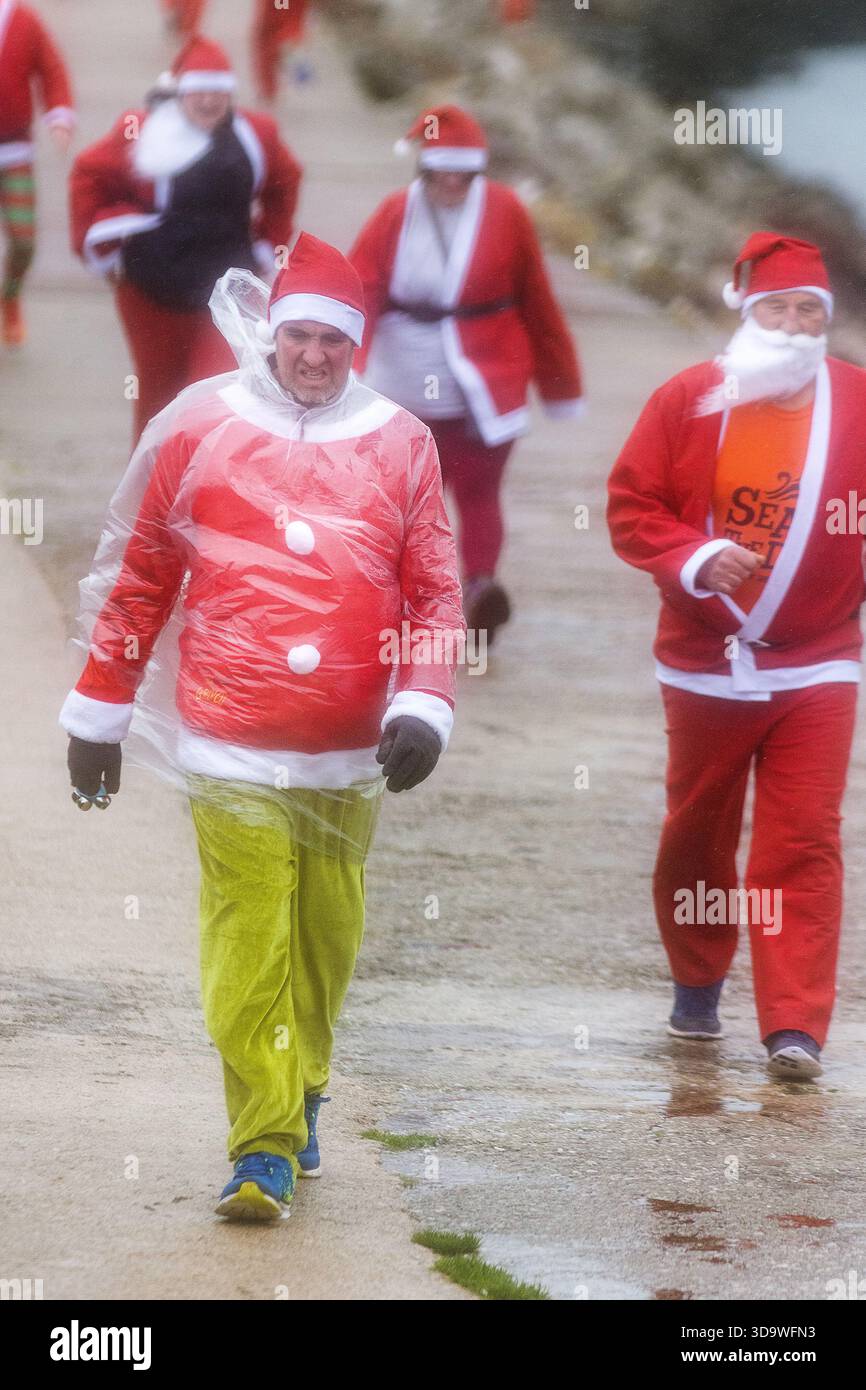 Brixham, UK, 7th Dec. 2025. Hundreds of Santas take part in the 2025 ...