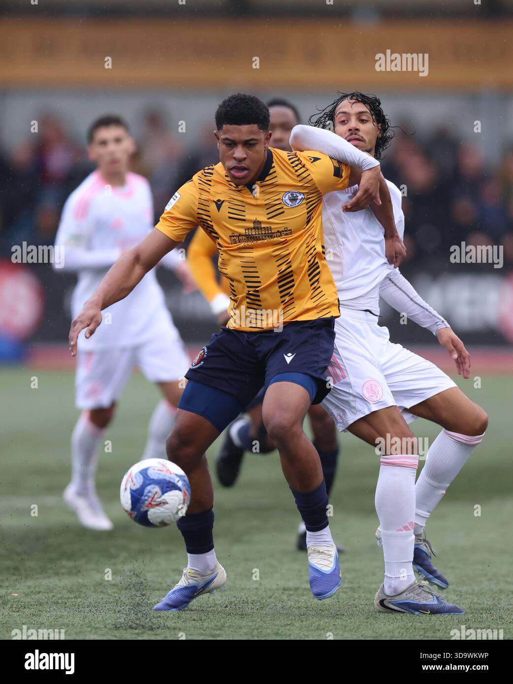 Slough Town's Tarik Gidaree shields the ball from Macclesfield's D'Mani ...