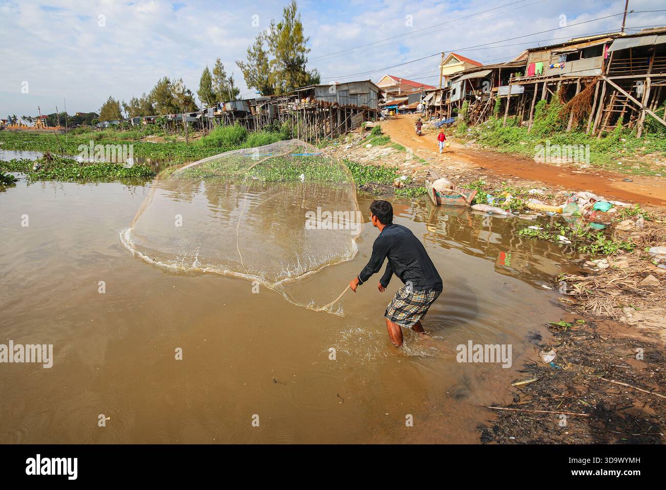 Tonle Sap River, Cambodia. Dec 07, 2025. Fisherman casting net using ...
