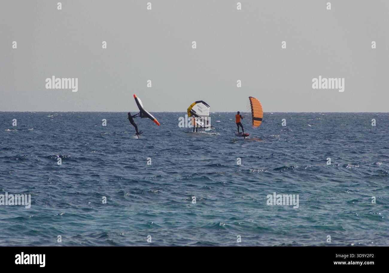 Group of windsurfers riding on the open sea on a windy day Stock Photo ...