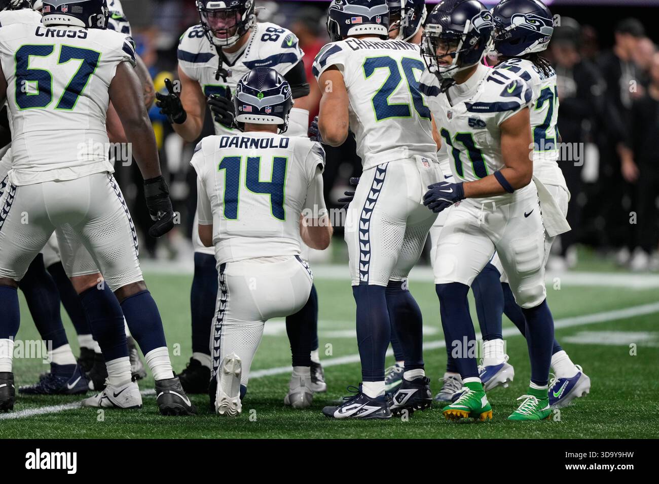 Seattle Seahawks quarterback Sam Darnold (14) huddles with his team ...