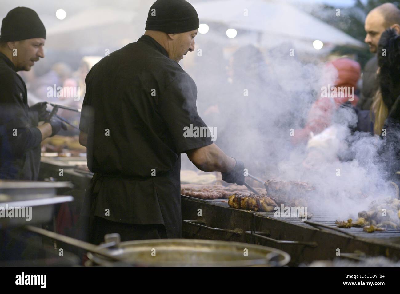 December 6, 2025 - Craiova, Romania: Chefs grill meat at a food stall ...