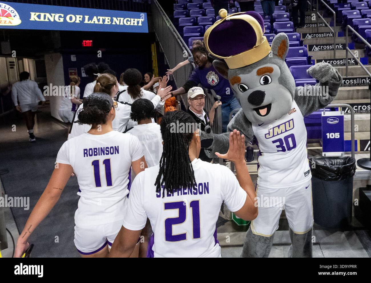 James Madison mascot Duke Dog, right, high-fives the team as they exit ...