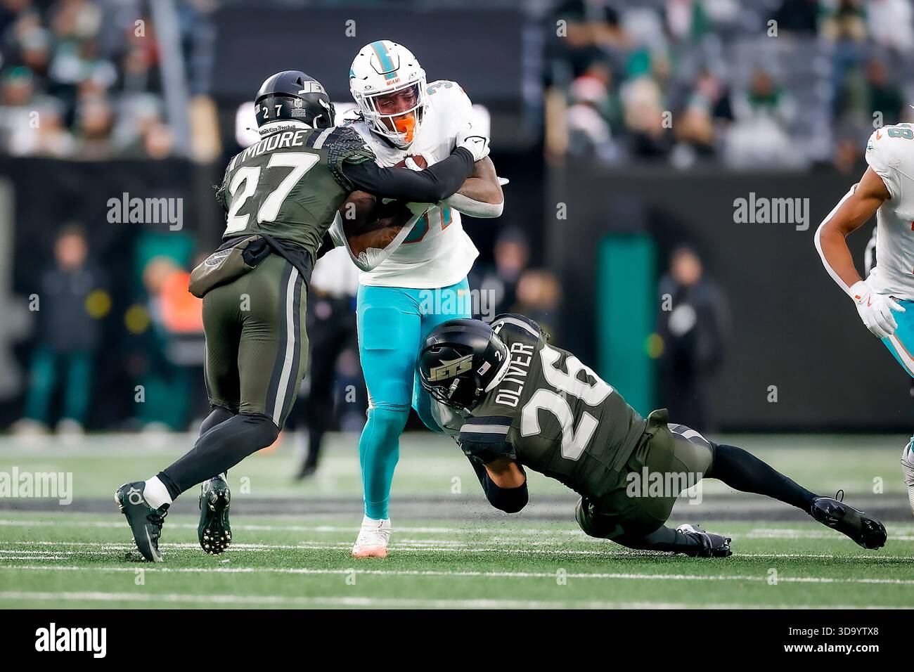Miami Dolphins running back Ollie Gordon II (31) is tackled by New York Jets safeties Malachi ...