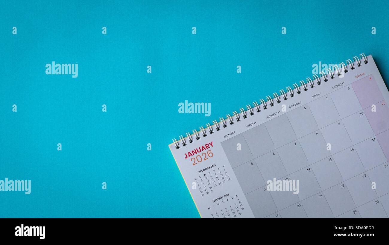 2026 table calendar with January 2026 page on top of blue plain paper ...