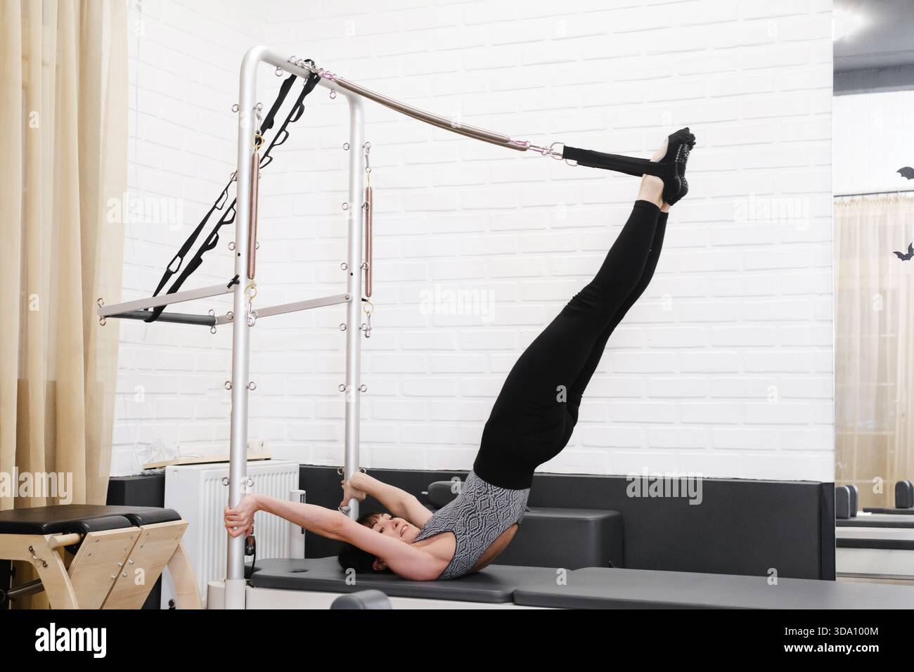 Woman training on pilates reformer with inversion technique, performing ...