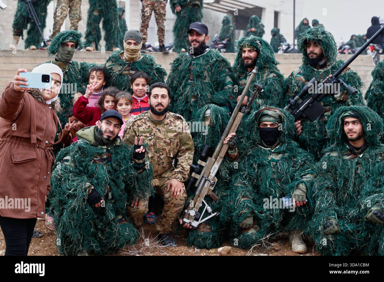A child takes a selfie with soldiers of the new Syrian army dressed in ...