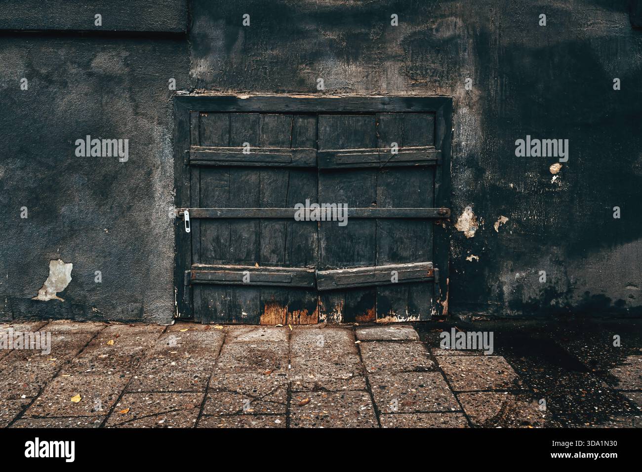 Moody close-up of an ancient, heavily weathered wooden door set in a ...