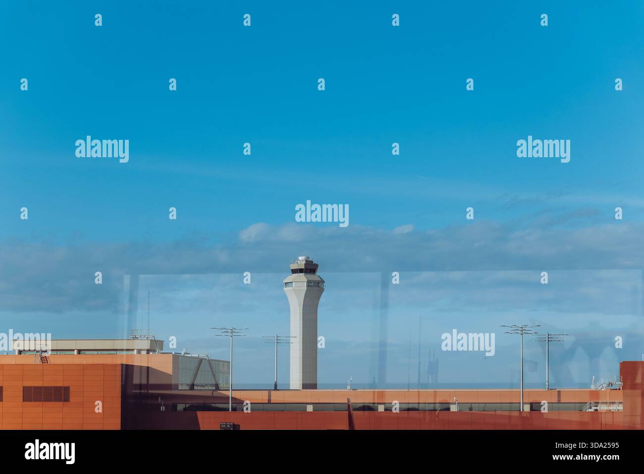 The airport control tower rises above the terminals under a clea Stock ...