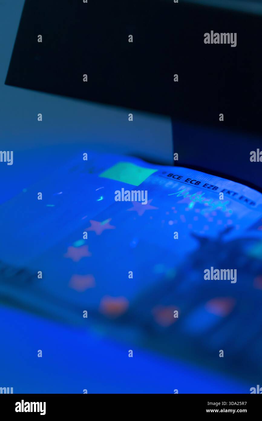 Currency testing under UV light reveals hidden features and security ...