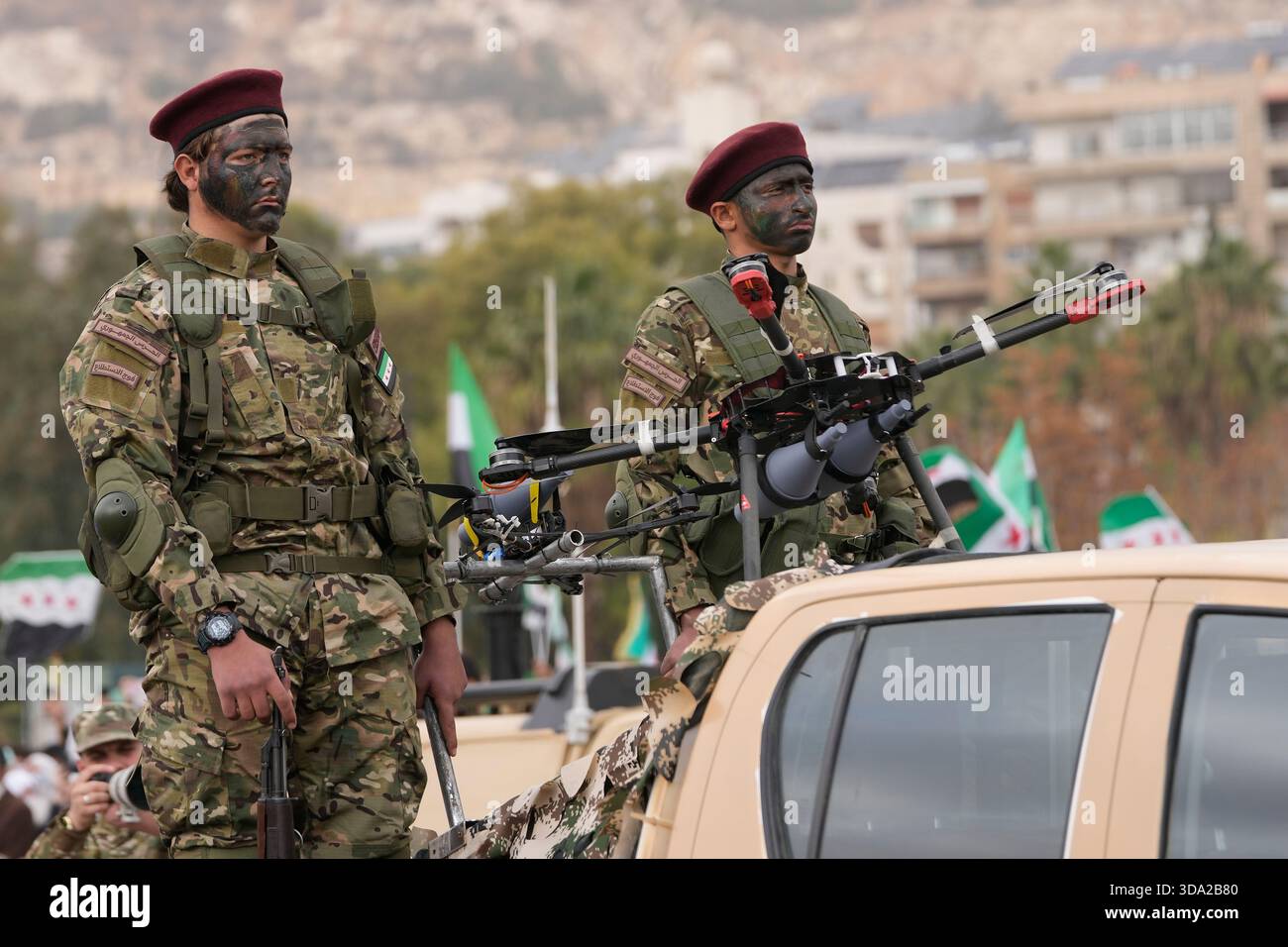 New Syrian army soldiers stand next of an armored drone during a parade ...